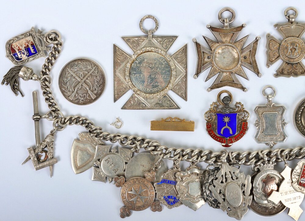 A large silver chain with multiple silver fob medals and coins