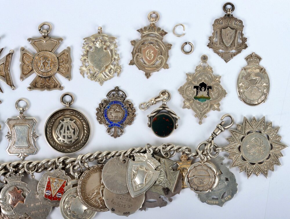 A large silver chain with multiple silver fob medals and coins