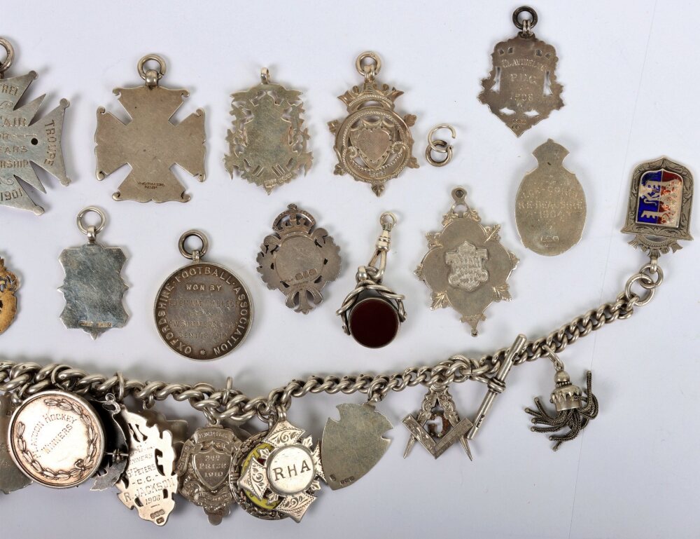 A large silver chain with multiple silver fob medals and coins